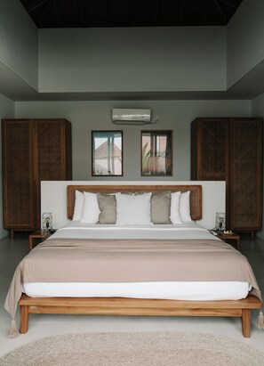 Quarto com uma cama grande, cabeceira de madeira, duas mesas de cabeceira e um ventilador de teto.