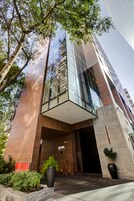 Um edifício moderno com fachada de vidro, entrada imponente e uma placa com a inscrição "QOVEL".