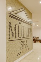 Parede revestida de azulejos com o texto "MULLER SPA" numa fonte estilizada.