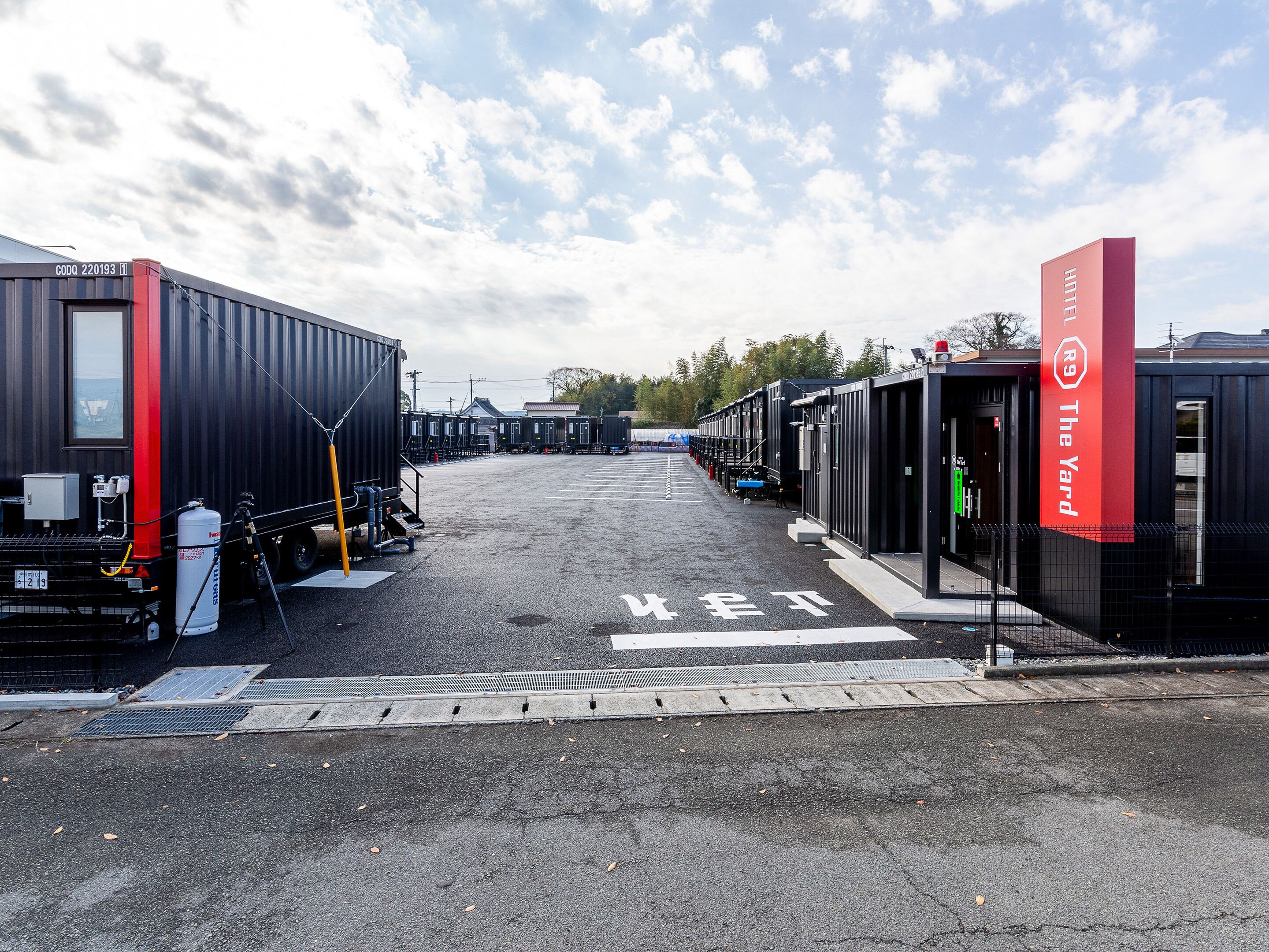 Um estacionamento com trailers e um edifício com a inscrição "HOBBY R9 The Yard".