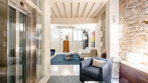 Sala de estar moderna com um sofá cinzento, uma mesa de centro e uma parede de pedra.