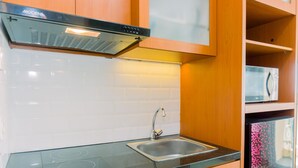 Uma cozinha moderna com pia de aço inoxidável, fogão por indução e armários de madeira.