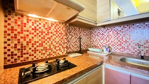 Uma cozinha com fogão a gás, pia e painel de azulejos.