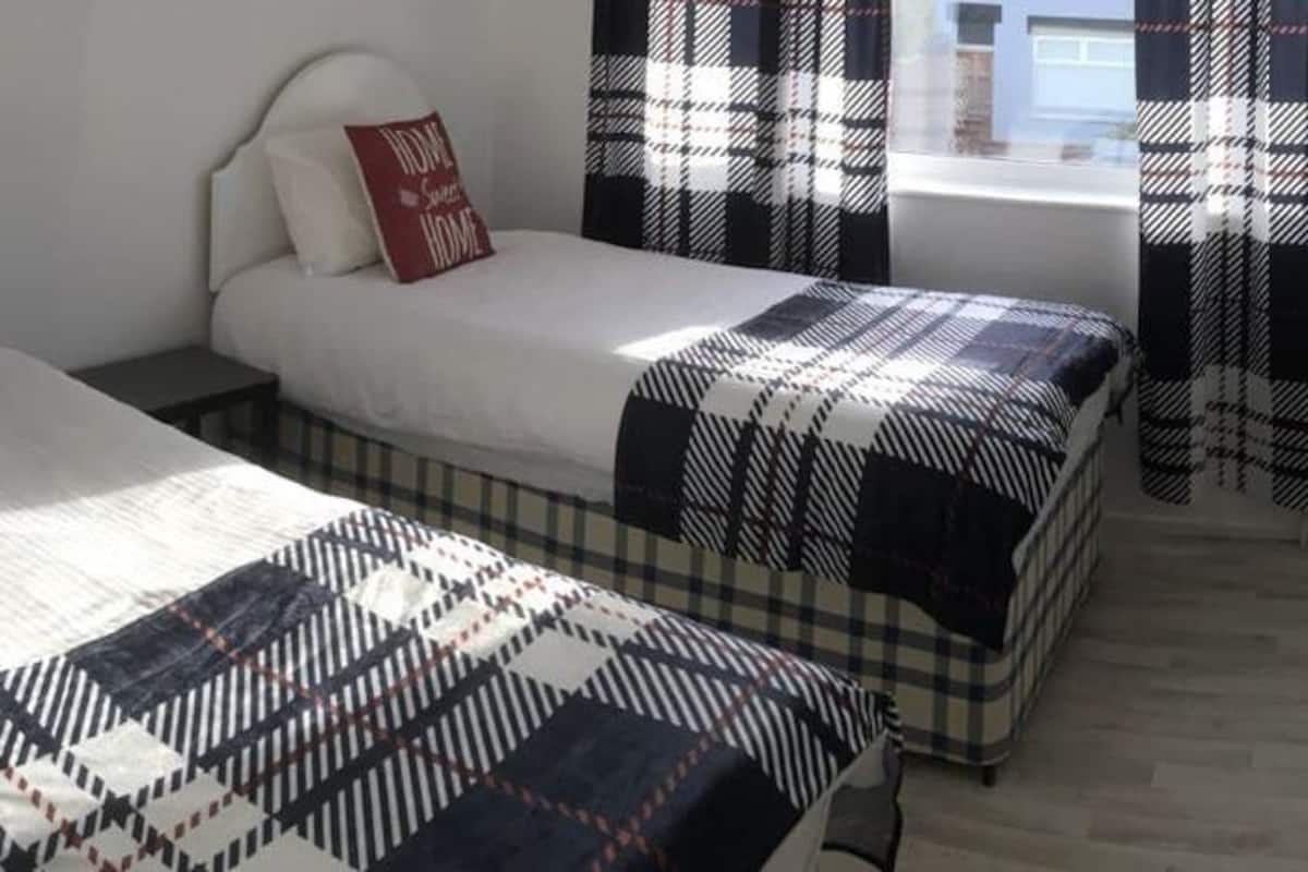Quarto com duas camas, cada uma com colcha de padrão diferente.