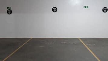 Uma garagem de estacionamento com vagas demarcadas e placas de sinalização.
