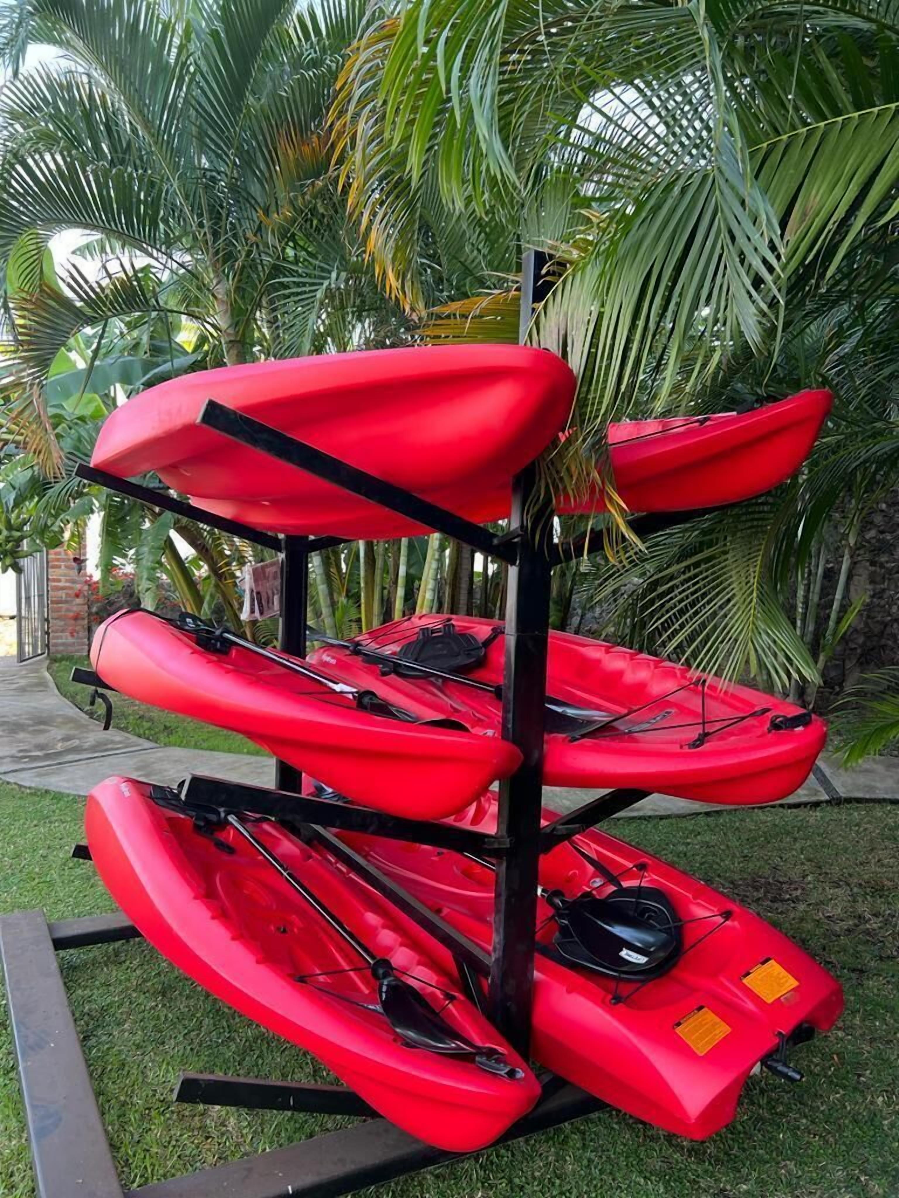 Suporte para caiaques em vários níveis, com diversos caiaques vermelhos.