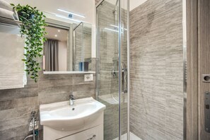 Quarto Duplo Premium | Casa de banho | Um polibã, um chuveiro fixo, um secador de cabelo, chinelos 