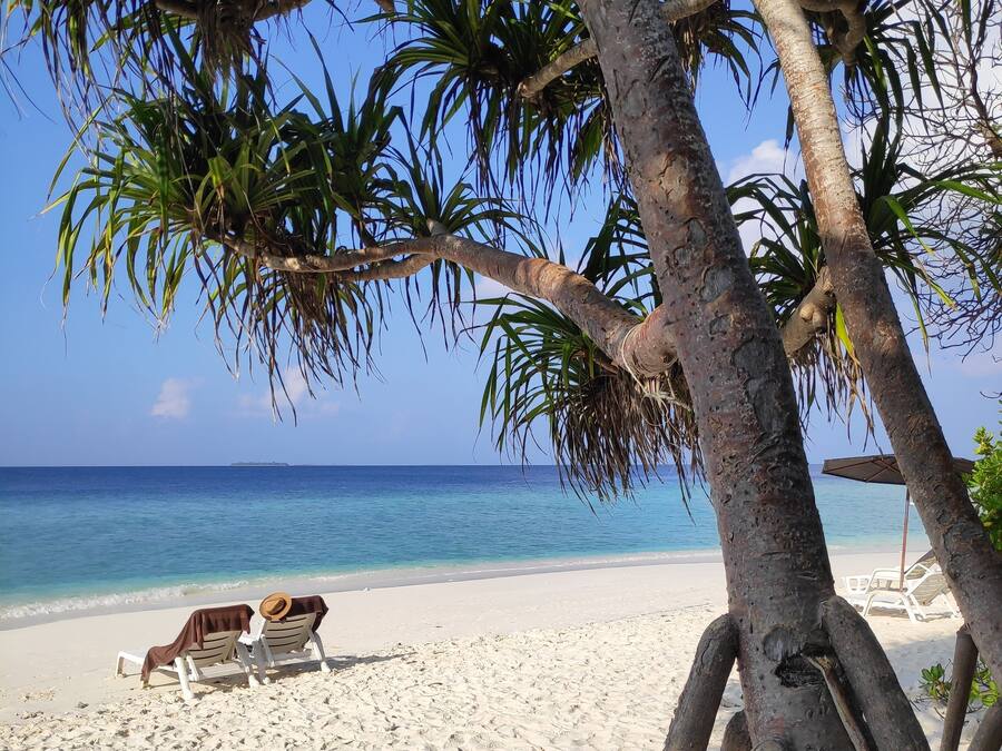 Na praia, praia de areia branca, espreguiçadeiras, guarda-sóis de praia