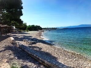 Perto da praia, praia de areia branca, espreguiçadeiras 