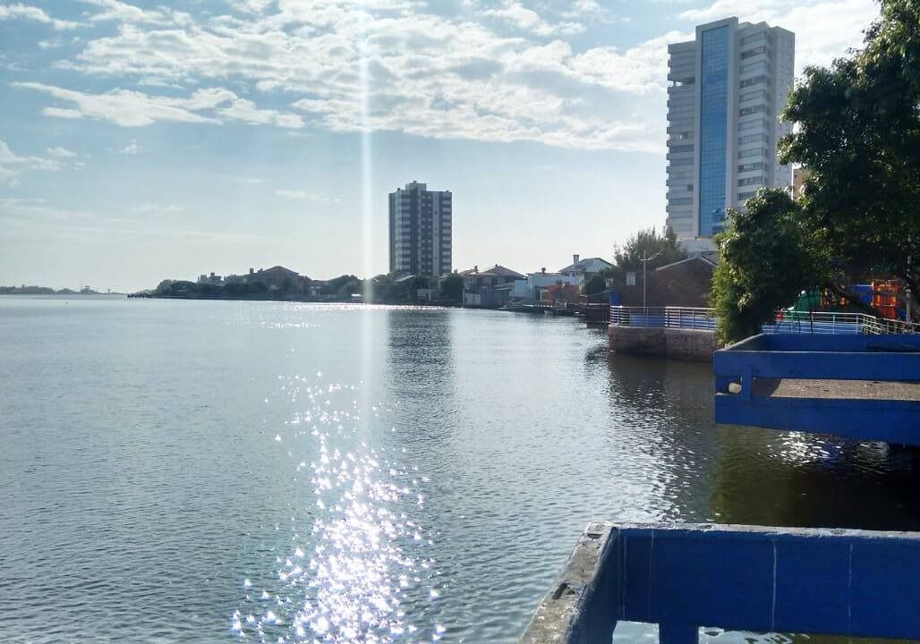 Um rio calmo com edifícios na margem oposta.