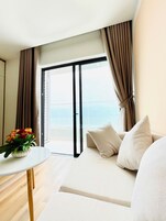 Apartamento Panorâmico, 2 quartos, varanda, em frente ao mar | Sala de estar | Televisor de ecrã plano de 55 polegadas com canais por cabo, televisor 