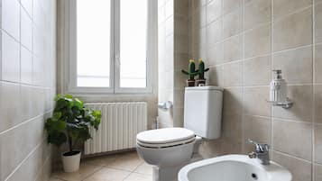 Apartamento Cidade | Casa de banho | Um polibã, um chuveiro fixo, um secador de cabelo, um bidé