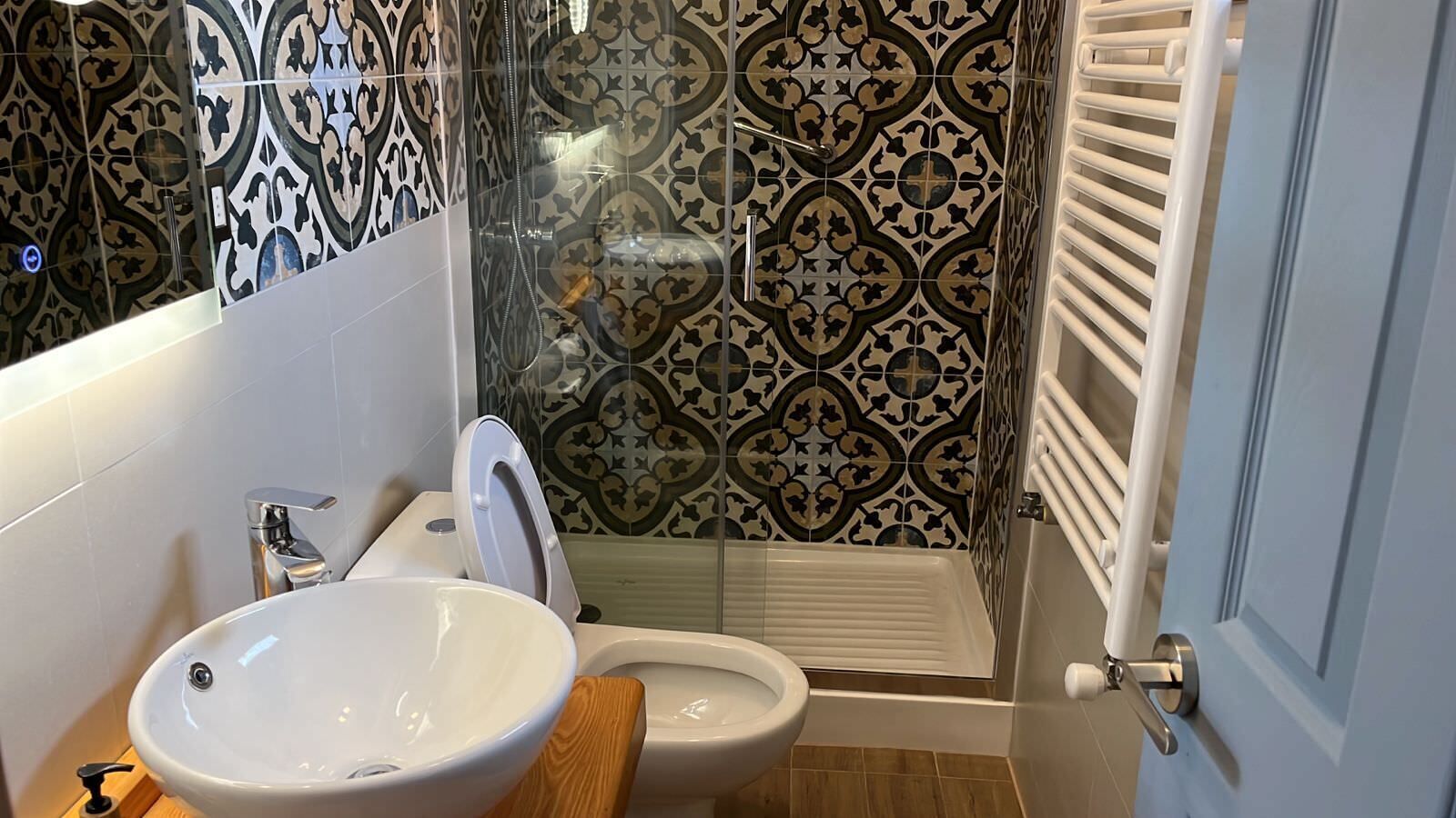Uma casa de banho com uma sanita, um lavatório branco e cabine de duche.
