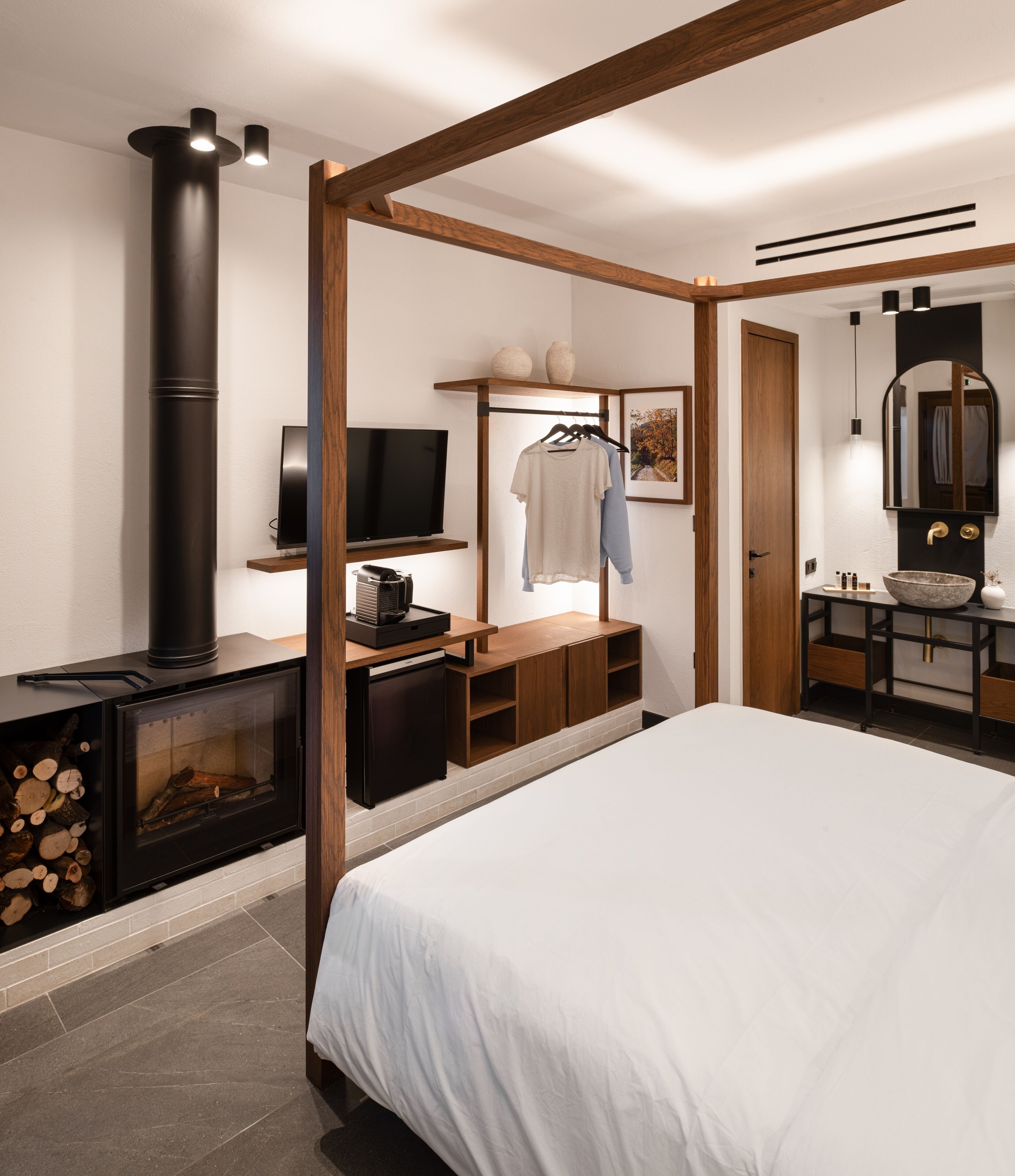 Um quarto moderno com uma cama grande, um guarda-roupa de madeira, uma televisão e uma lareira.