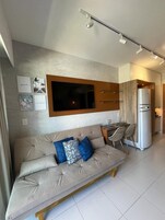 Uma sala de estar moderna com sofá, área de jantar e cozinha.