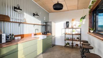 Uma placa de cozinha, uma cafeteira/bule, uma chaleira elétrica
