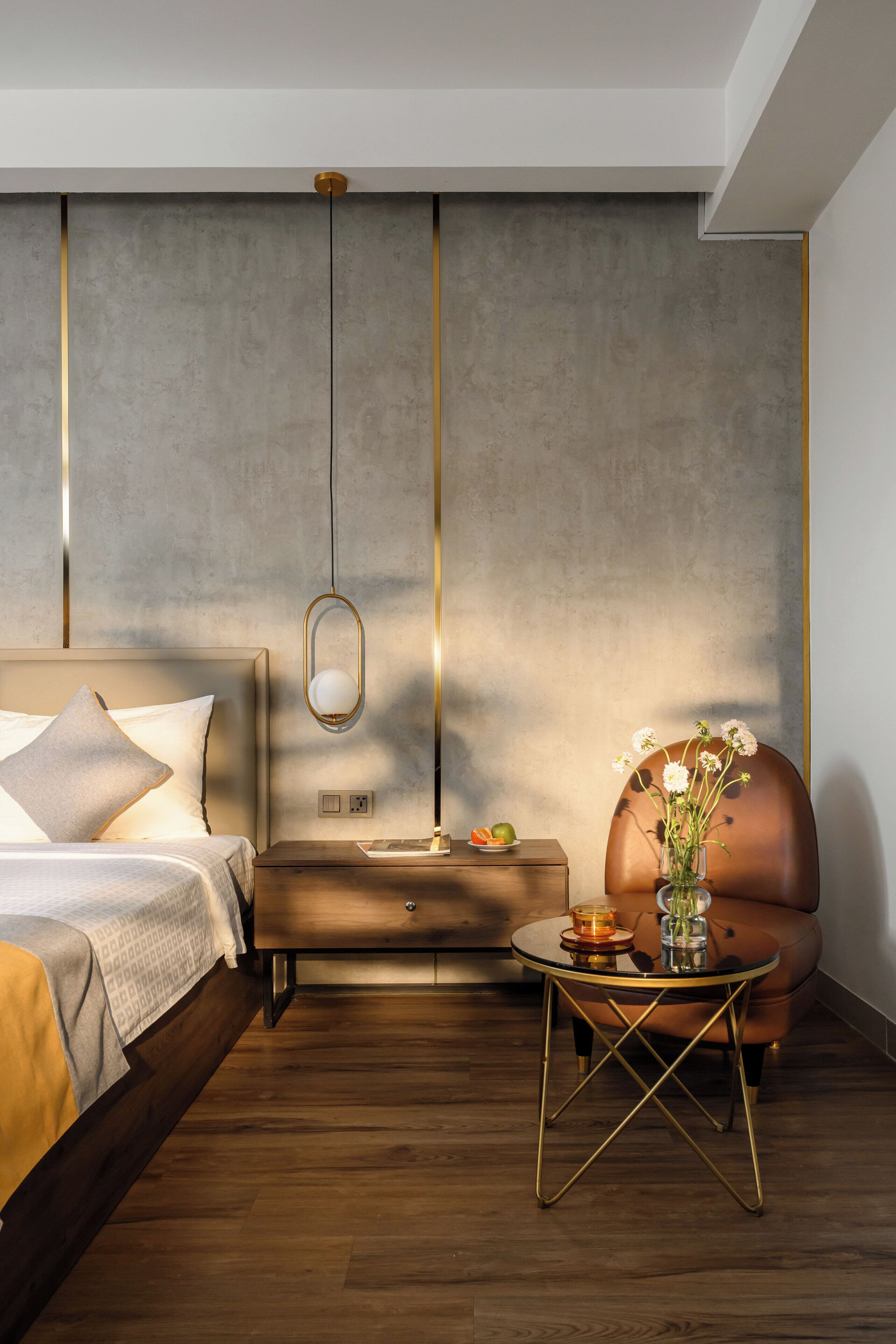 Quarto moderno com cama, mesa de cabeceira e uma cadeira.