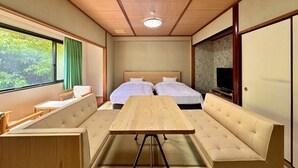 Quarto com cama, sofá, mesa e televisão.