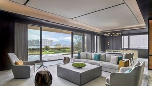 Uma sala de estar moderna com uma janela grande, um sofá, uma mesa de centro e um vaso decorativo.
