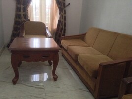 Uma sala de estar com uma mesa de centro de madeira e um sofá.