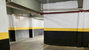 Uma garagem de estacionamento com pisos de concreto e paredes pintadas em amarelo e preto.