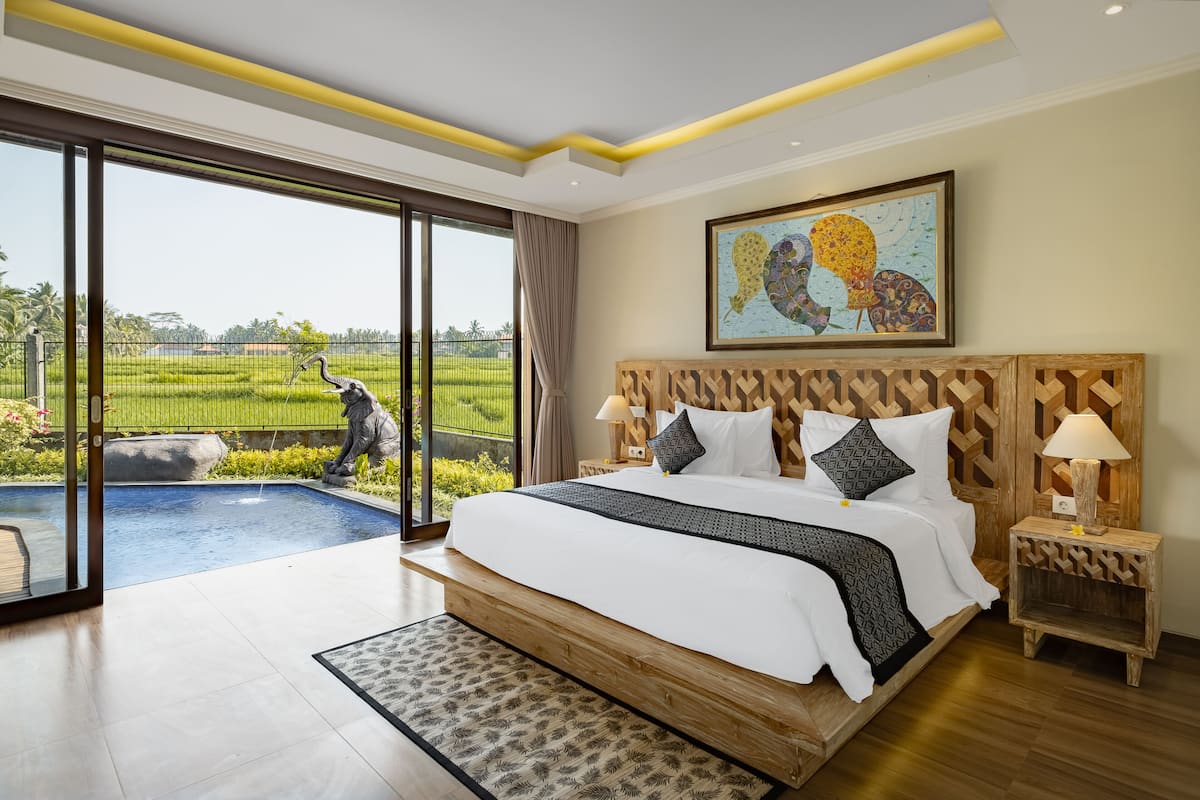 Quarto com uma cama grande, vista para uma piscina e cabeceira de madeira.