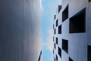 Um edifício moderno com fachada geométrica e várias sacadas.