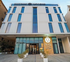 Um hotel moderno com fachada imponente, grandes janelas e um logotipo na fachada.