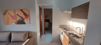 Uma cozinha moderna com pia, bancada e um quadro na parede.