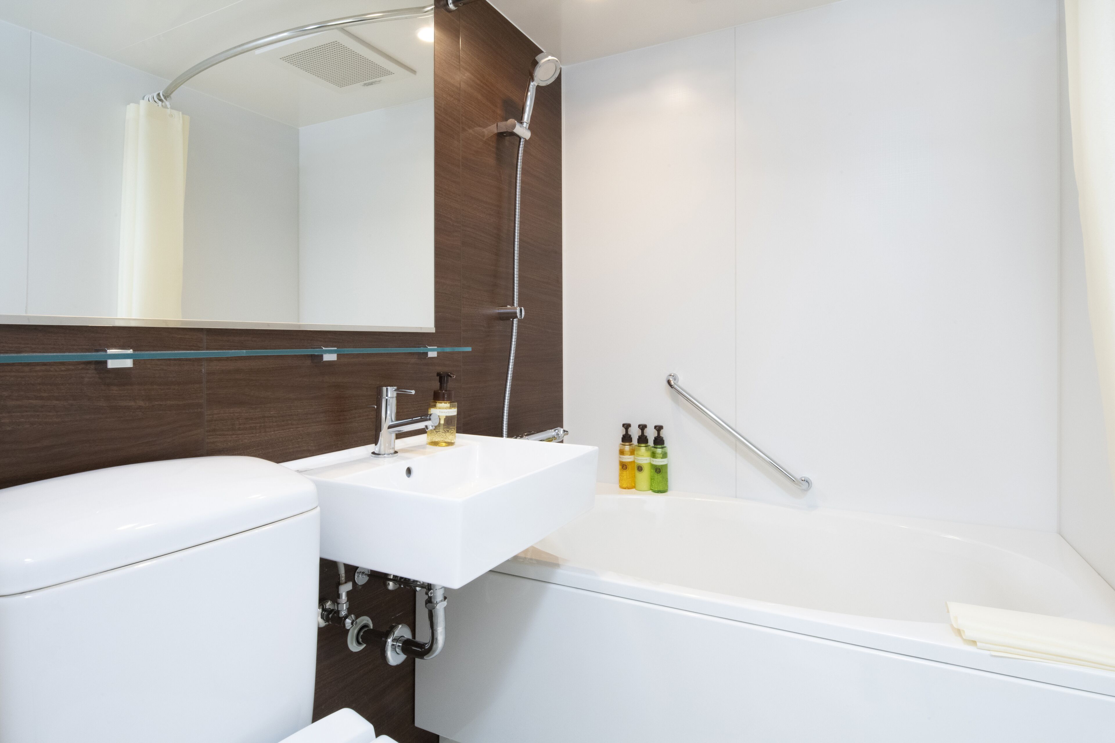 Casa de banho moderna com lavatório branco, espelho e banheira.