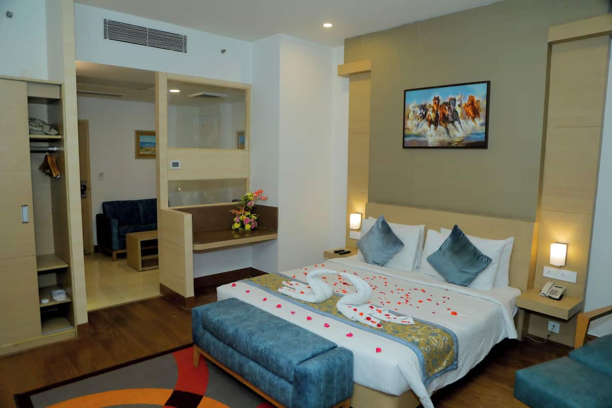 Quarto de hotel com cama, escrivaninha, cadeira, guarda-roupa e um quadro na parede.