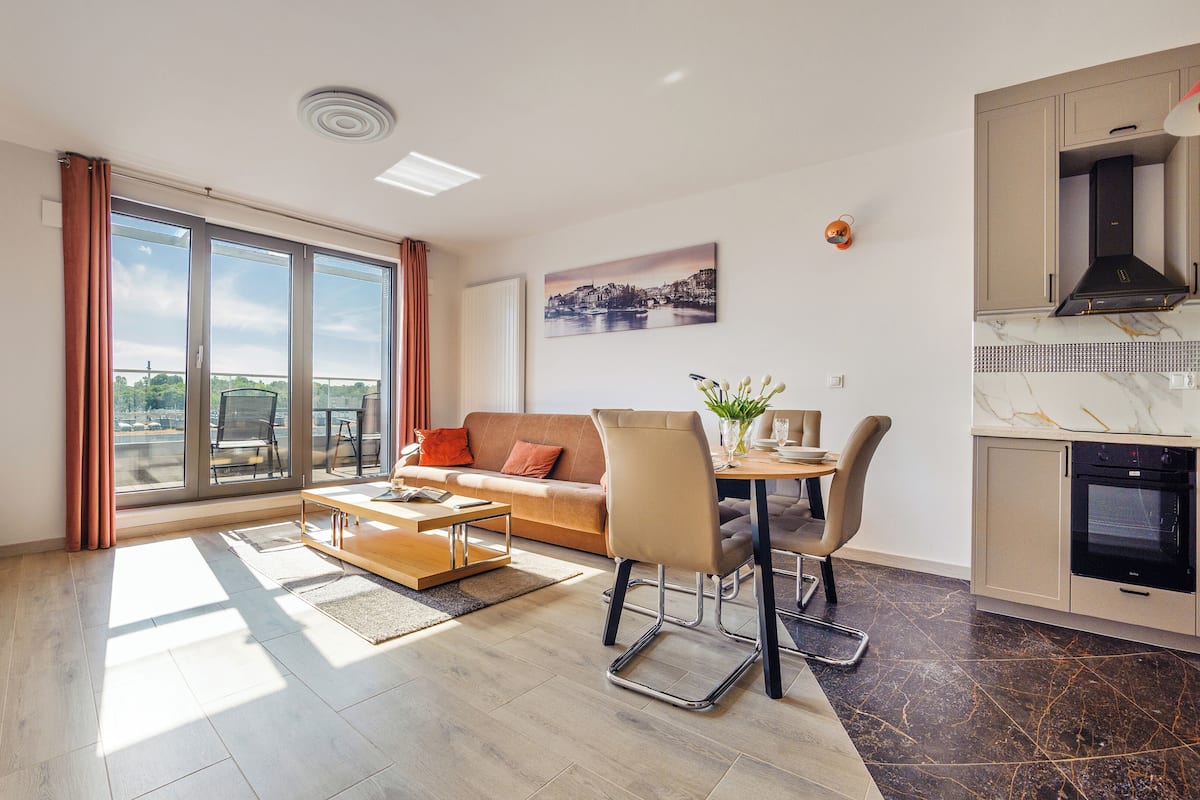 Um apartamento moderno com sala de estar, sala de jantar e cozinha.