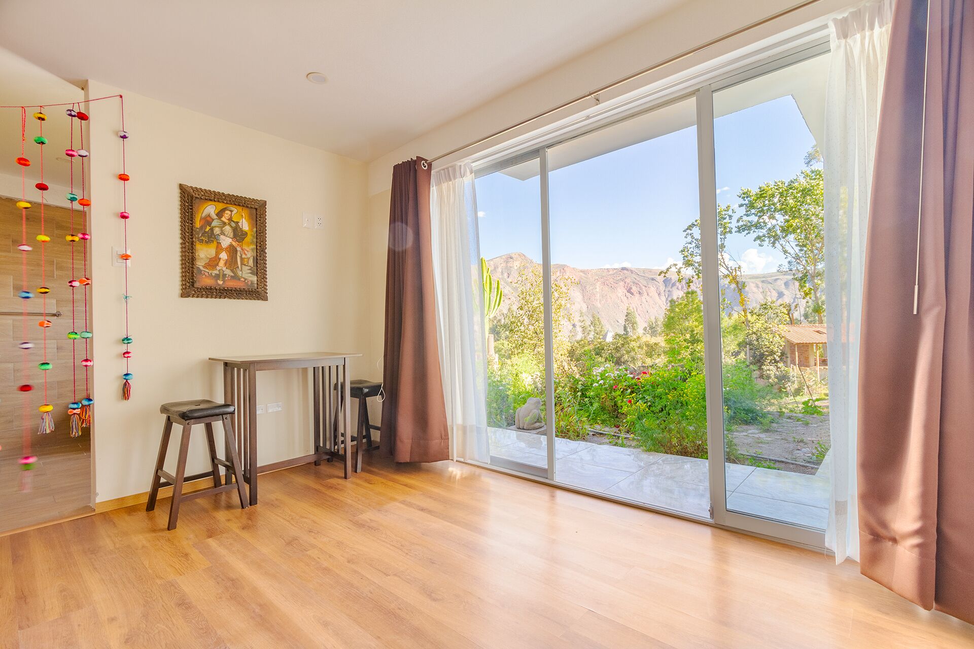 Quarto espaçoso com uma grande porta de correr de vidro que dá para um jardim.