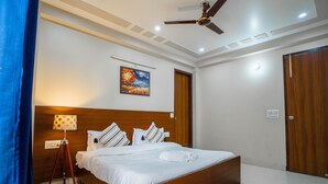 Um quarto bem arrumado com uma cama de madeira, um ventilador de teto e um quadro na parede.