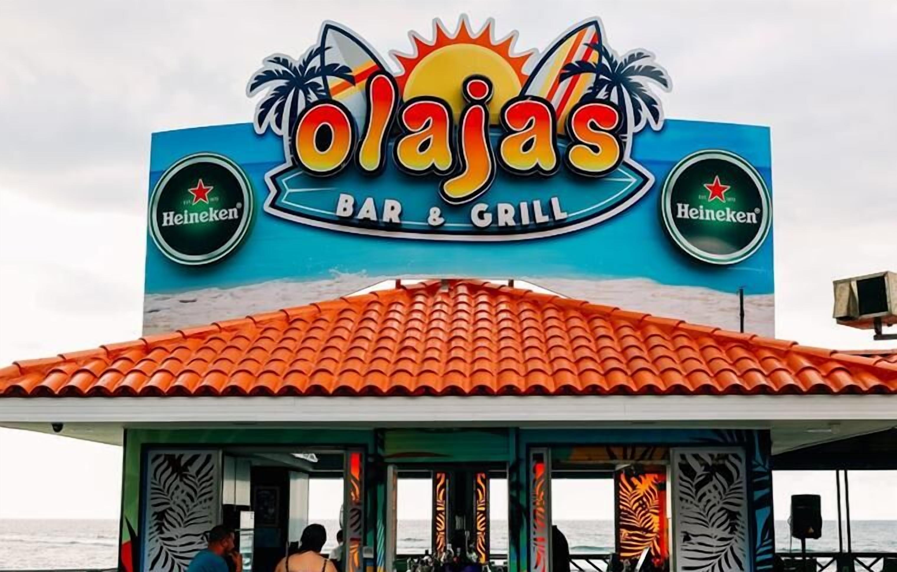 Um bar e restaurante à beira-mar chamado 'Olajas', com marca Heineken.
