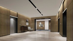 Um hall moderno e espaçoso com balcão de recepção, área de estar e atendimento.