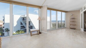 Varanda ampla com vista para um edifício moderno e palmeiras.