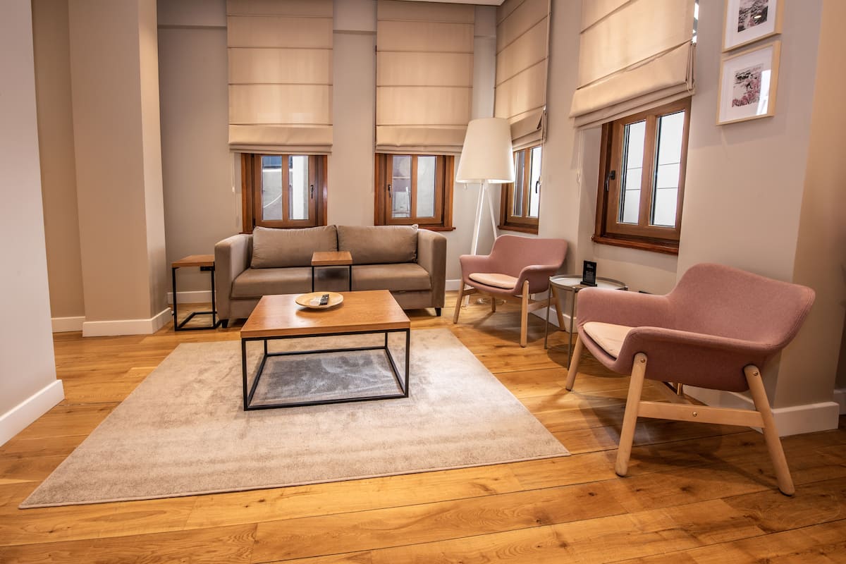 Sala de estar com sofá, poltrona, mesa de centro e abajur.