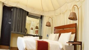 Quarto espaçoso com cama grande, cabeceira de madeira e dossel.