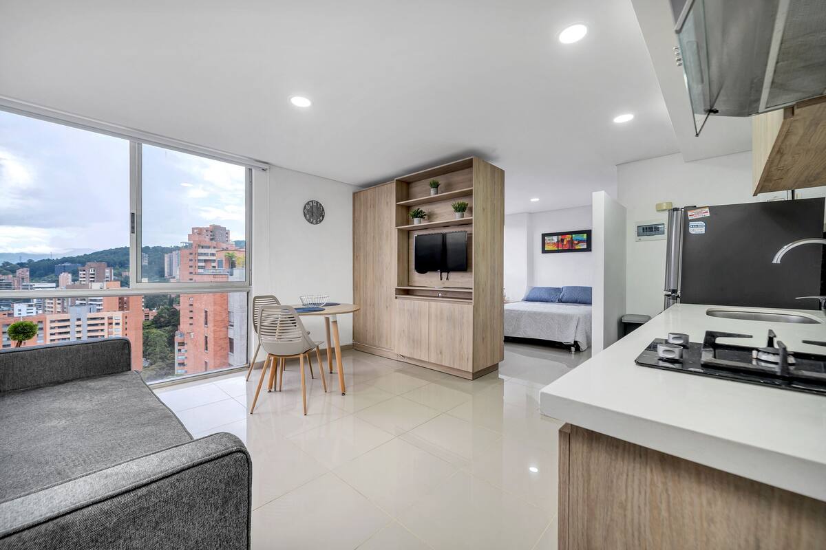 Um apartamento moderno com cozinha, sala de jantar e sala de estar com uma janela grande.