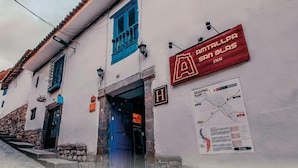 Um edifício com uma placa vermelha que diz 'AMTALLPA SAN BLAS INN'.