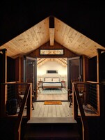 Uma cabana acolhedora com quarto no mezanino, fachada de madeira e uma pequena varanda.