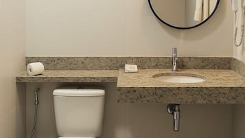 Uma casa de banho moderna com sanita, lavatório e espelho.