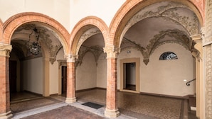 Pátio interior com piso de tijolos, tetos em arco e um espaço aberto central.