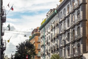 Uma fileira de edifícios históricos com vários andares, varandas e uma placa de proibido a entrada.