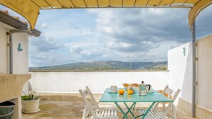Uma mesa com cadeiras e vista para a paisagem.