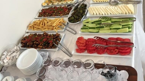 Uma mesa de buffet com diversos alimentos e utensílios.
