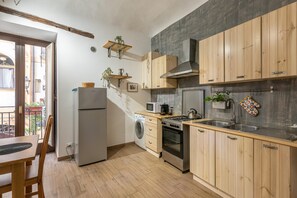 Uma cozinha compacta com armários de madeira, forno embutido, micro-ondas e pia.