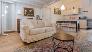 Uma sala de estar com sofá, mesa de centro e um espaço de jantar com cadeiras e mesa.