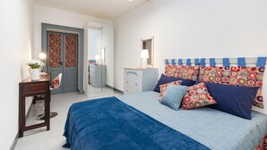Quarto com cama, penteadeira e espelho.
